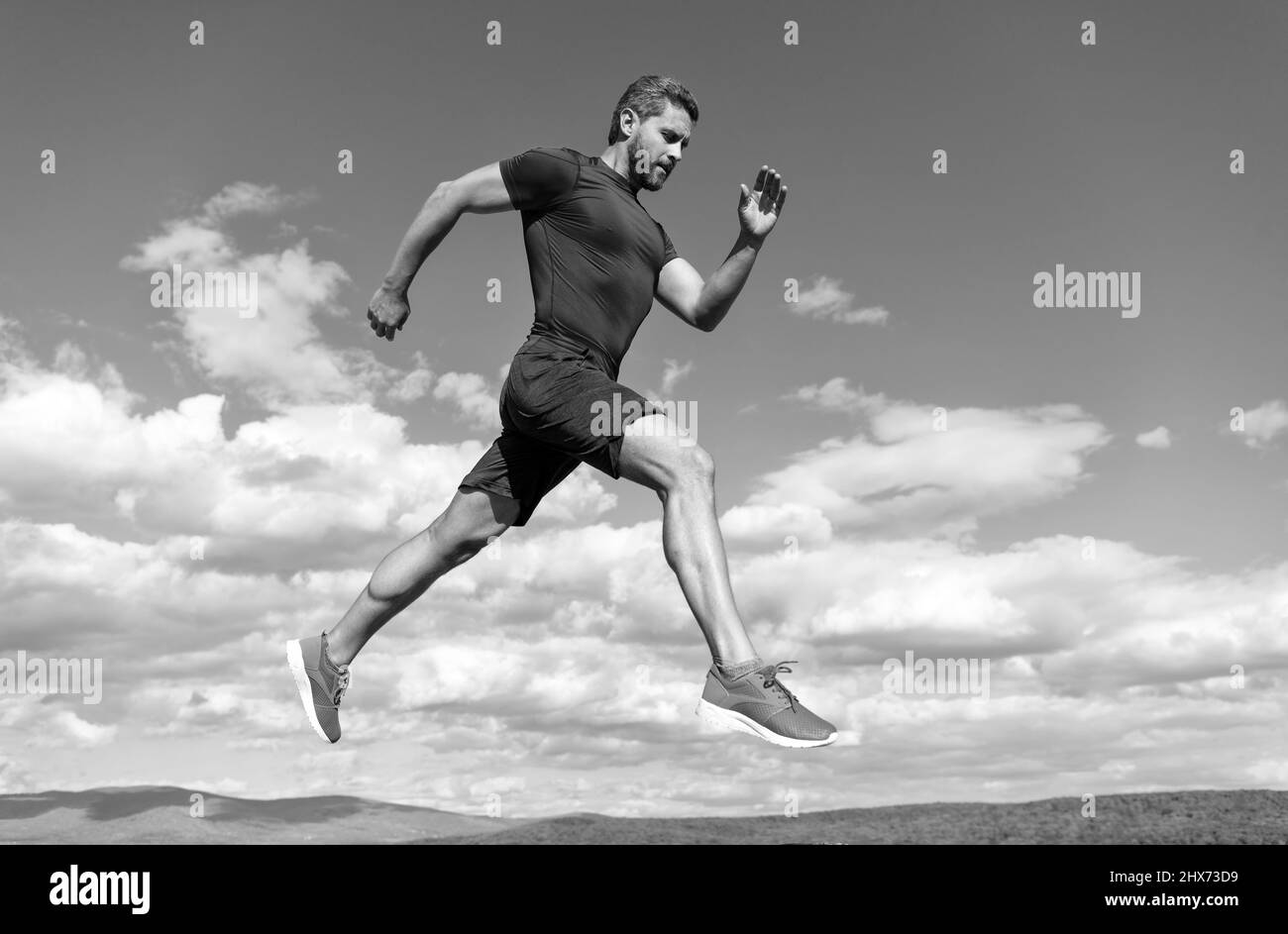 sportsman man runner run to success or jump high on sky background ...