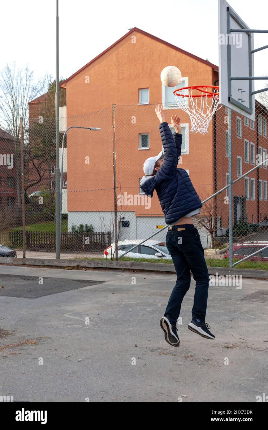 Teenage boy scoring basketball shot Stock Photo - Alamy