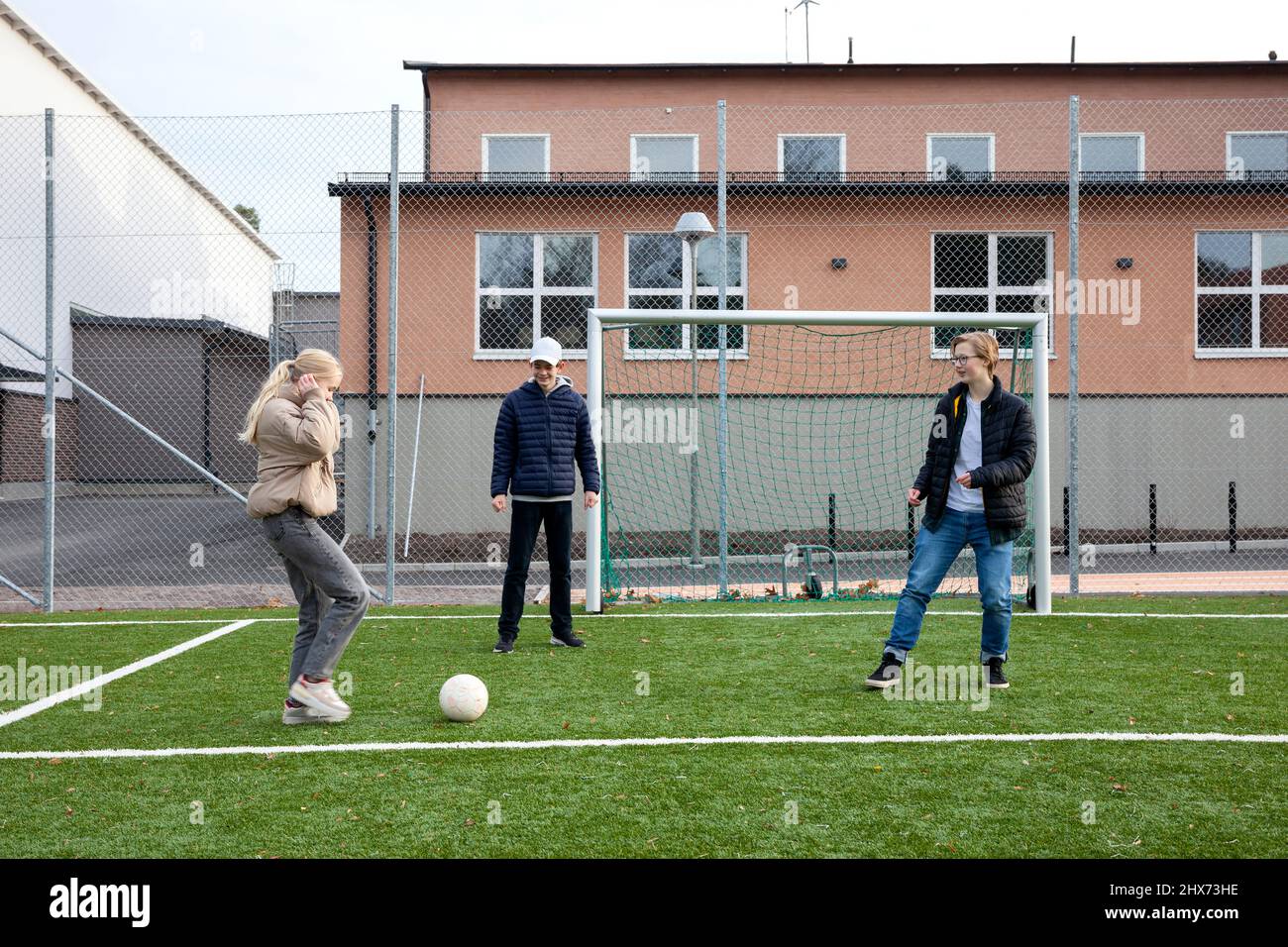 Friends playing soccer on school soccer field Stock Photo - Alamy
