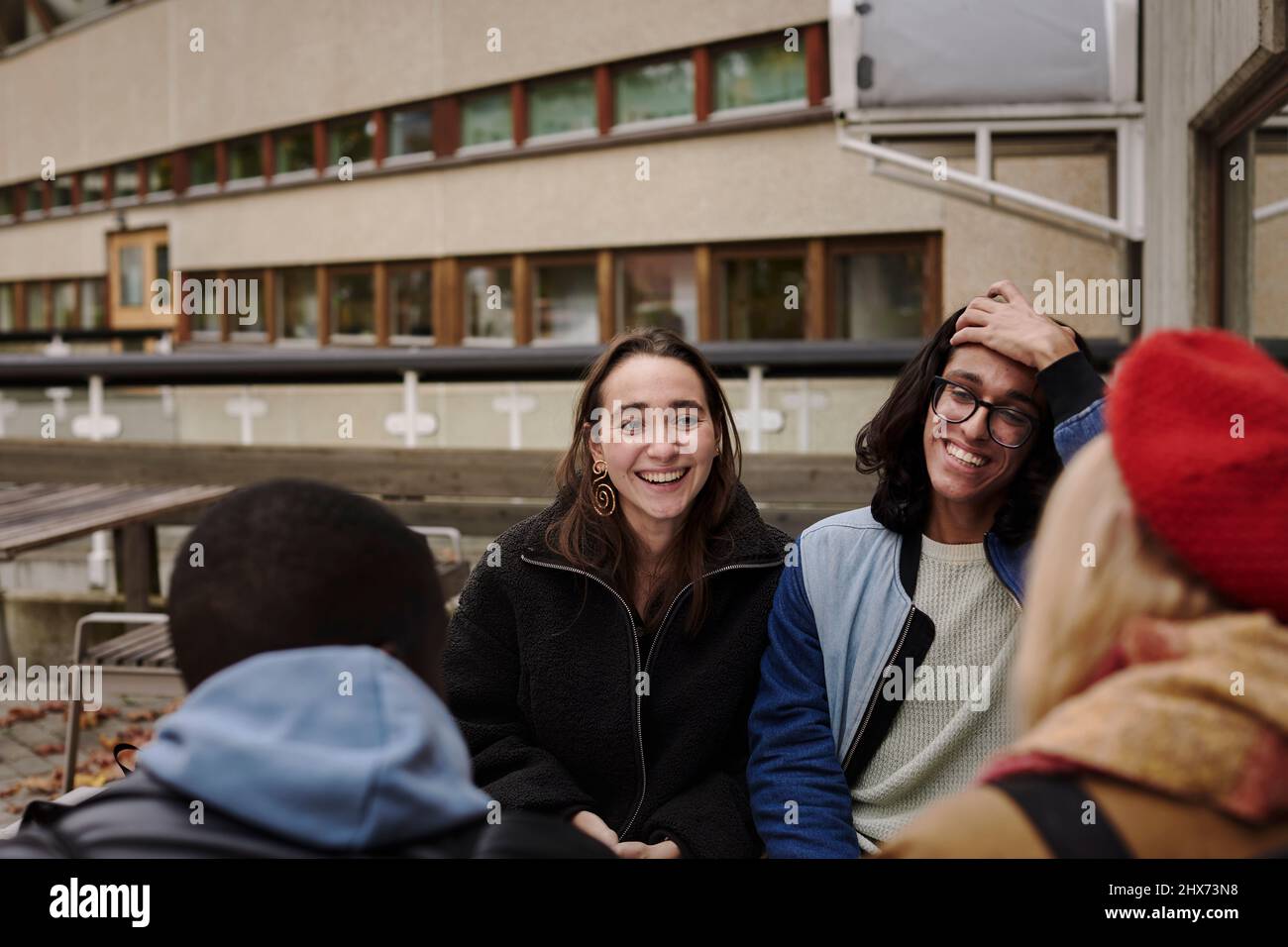 Young friends sitting together Stock Photo - Alamy