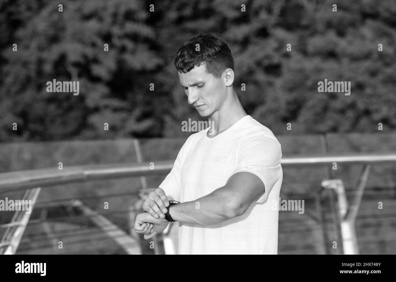 Athletic man check time on wrist watch during outdoor training, sports ...