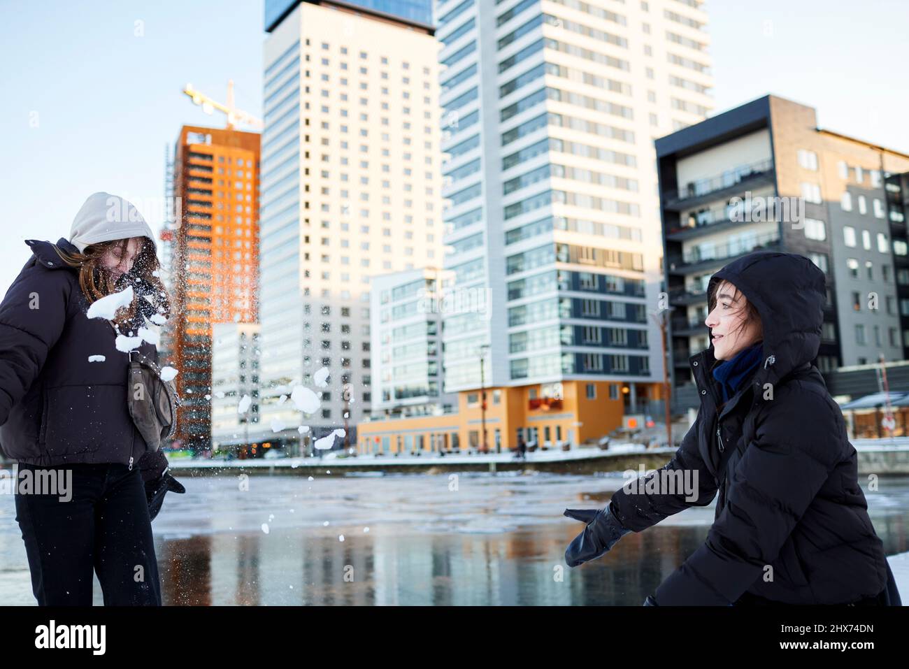 Young women having snowball fight Stock Photo - Alamy