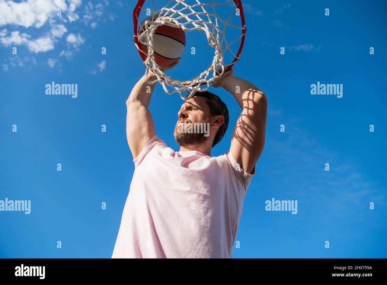 dunk in basket. slam dunk in motion. sunny summer activity. man with ...