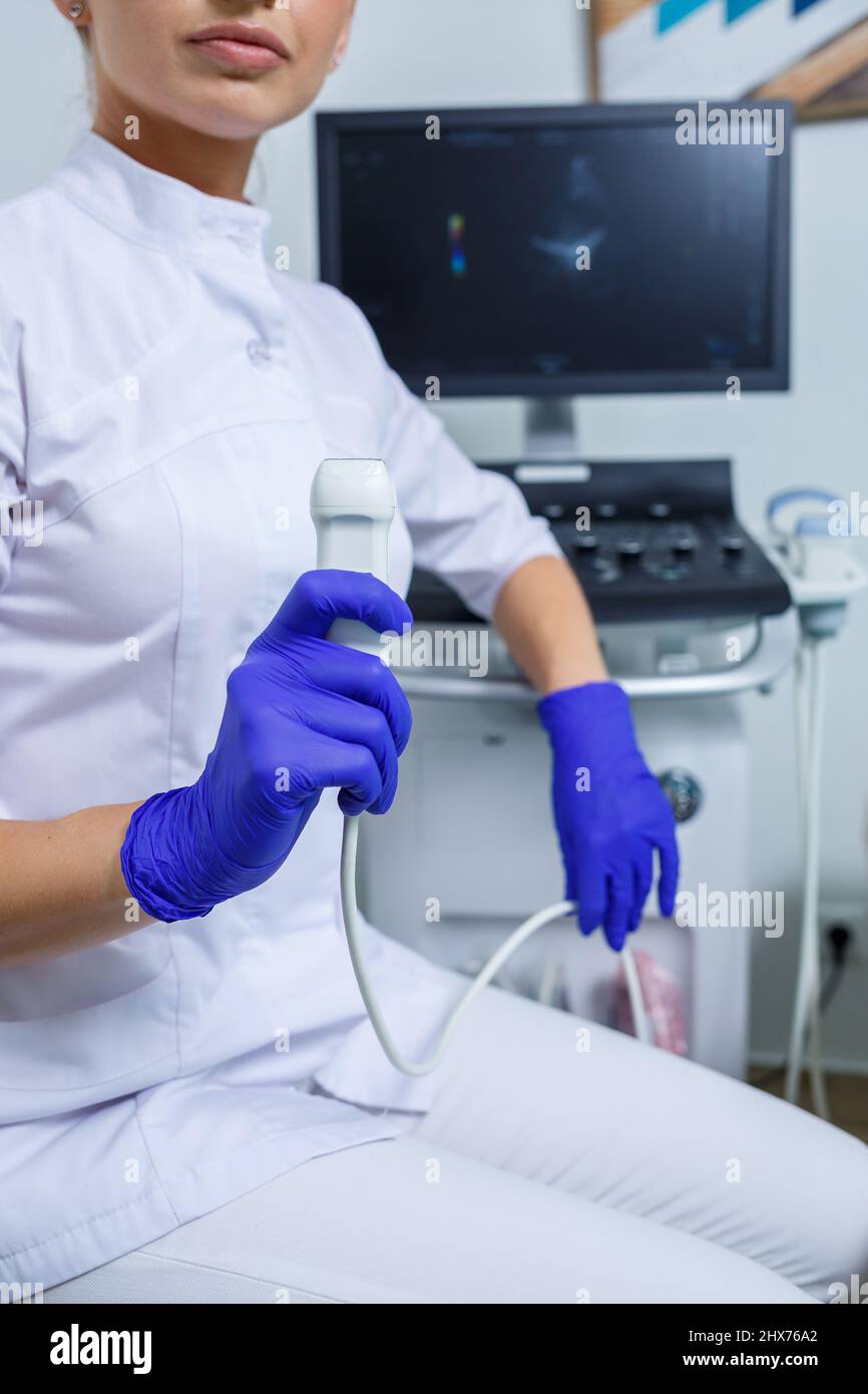 A young woman is an intern doctor, she is in a white suit and medical ...