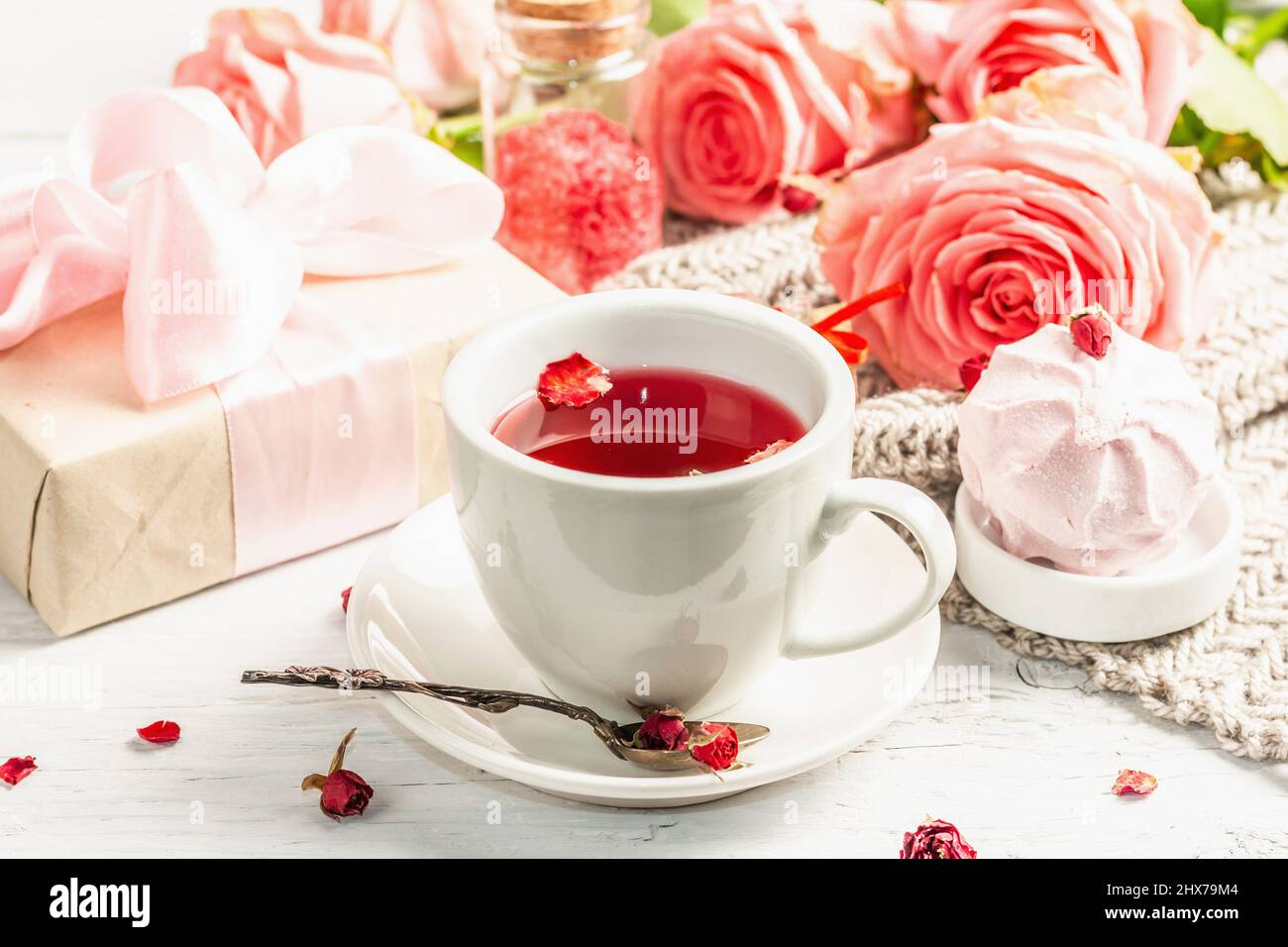 The concept of romantic tea. Wrapped gift, hibiscus tea, a bouquet of ...