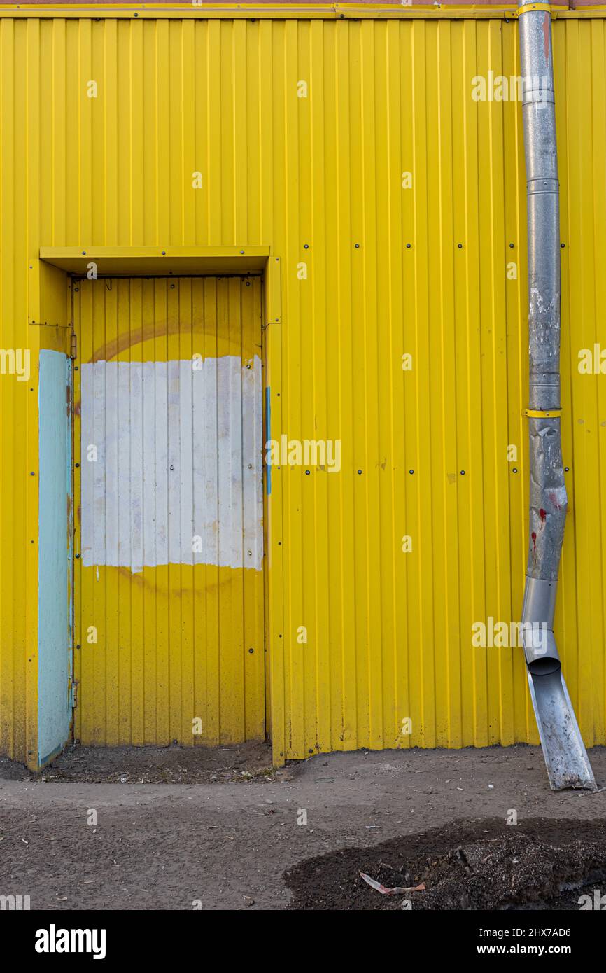 blocked entrance to a yellow colored building next to a drain pipe ...