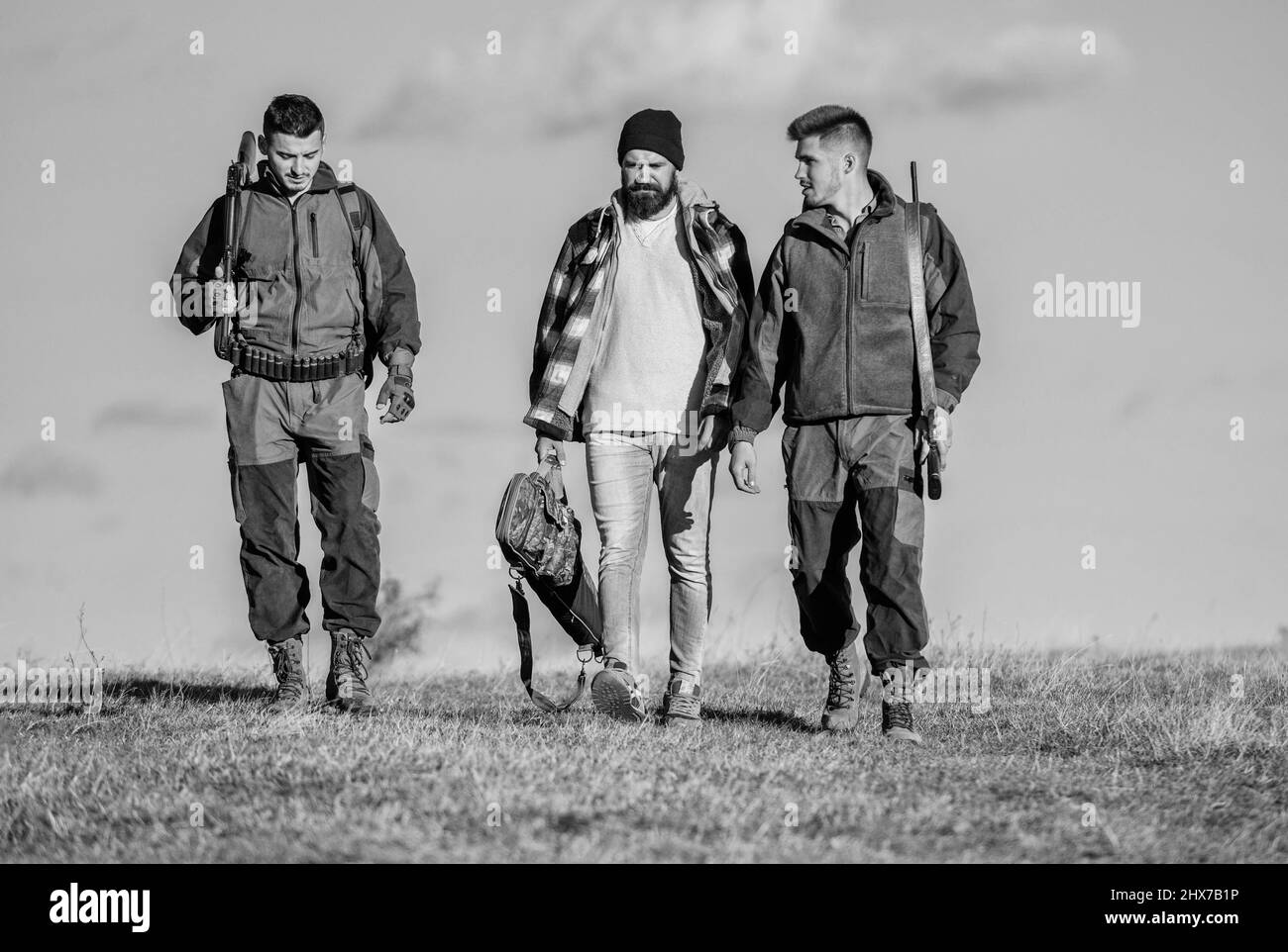 Group men hunters or gamekeepers nature background blue sky. Guys ...