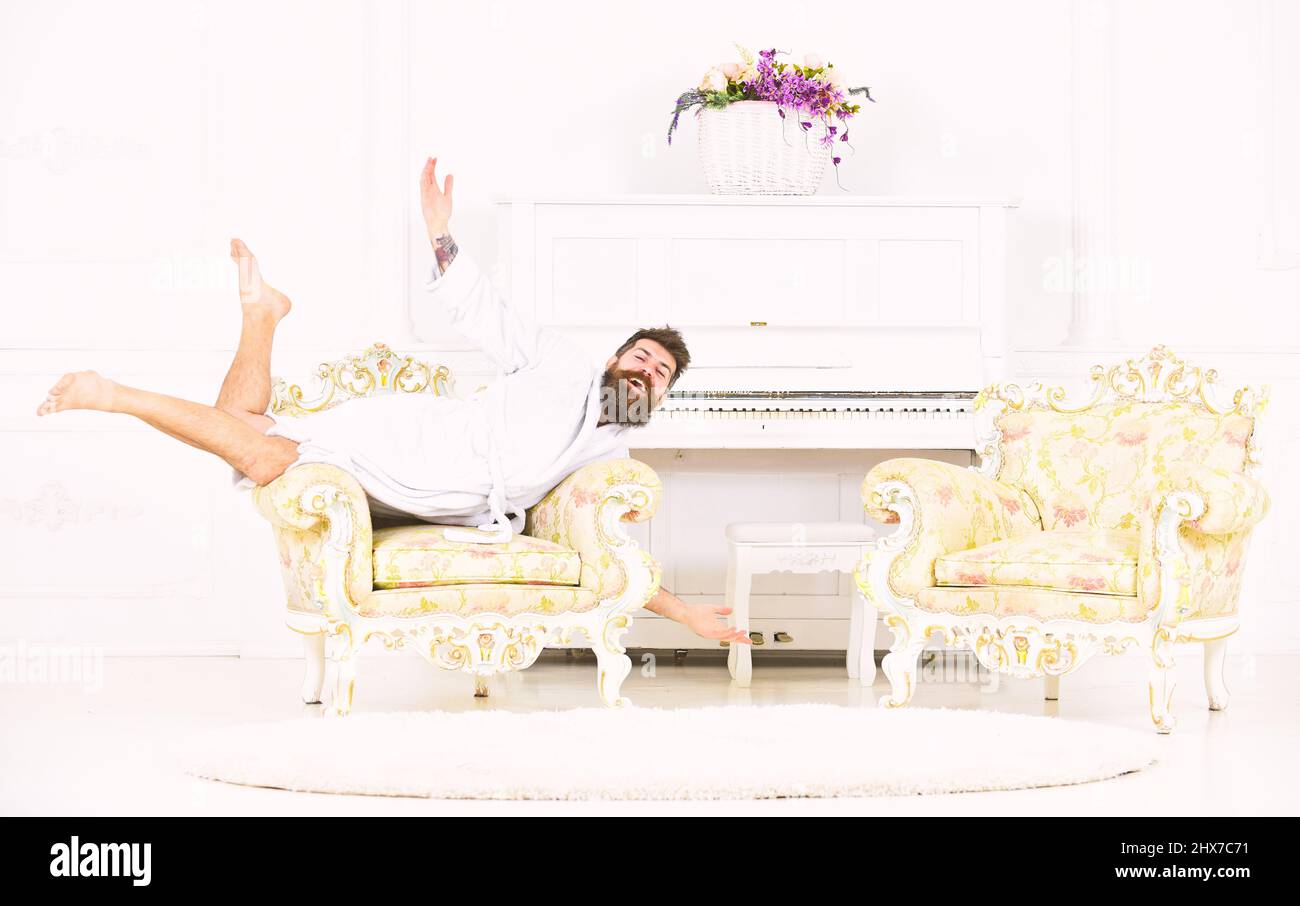 Bizarre man posing in armchair. Odd guy lying on antique furniture ...