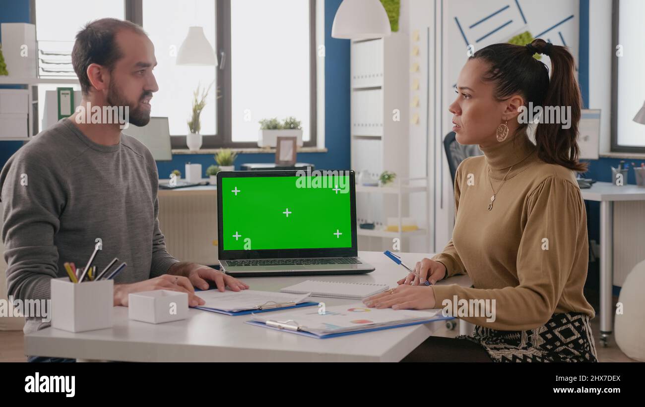 Colleagues working with green screen on laptop on desk. Team of ...