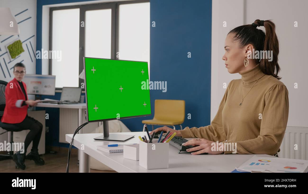 Business woman looking at green screen on computer, using isolated ...