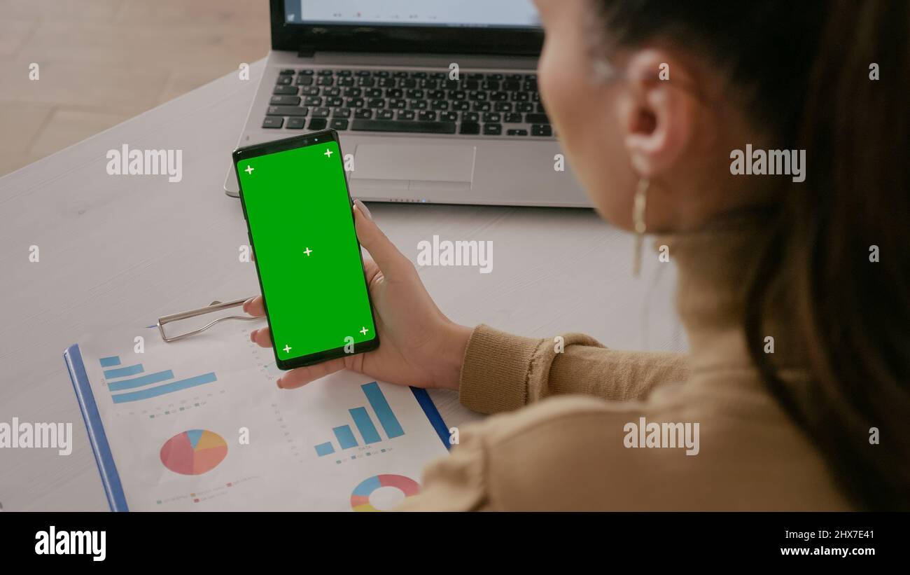 Close up of woman looking at telephone with green screen and chroma key ...