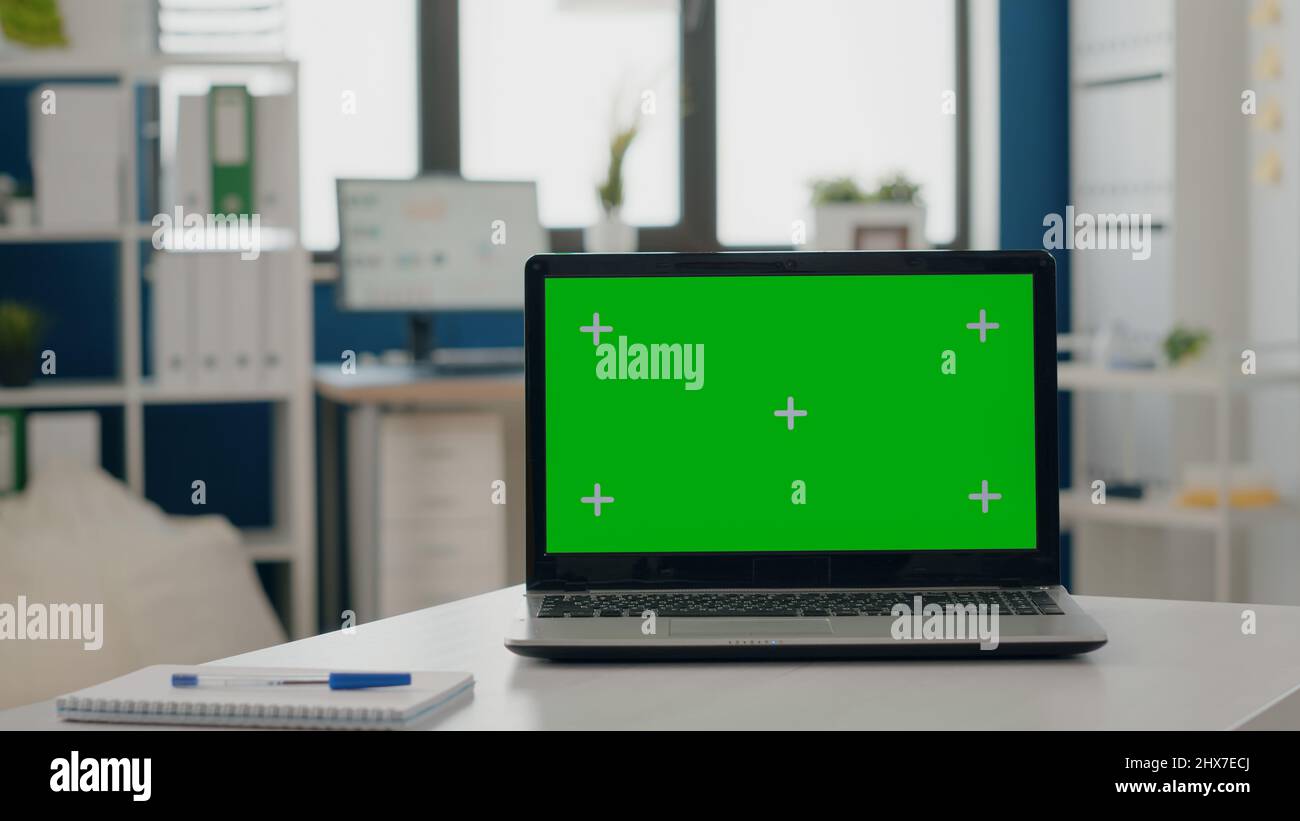 Close up of green screen on laptop at empty desk. Nobody at desk with ...