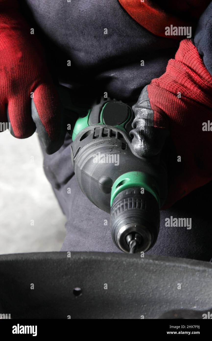 worker with drill in hand in factory Stock Photo - Alamy