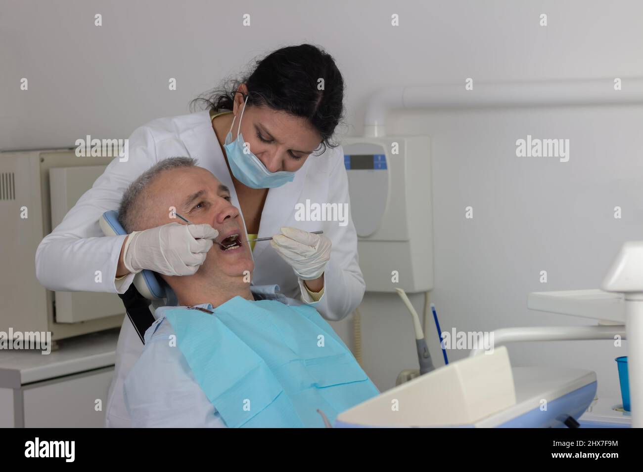 Male patient with open mouth receiving dental inspection at dentist's ...