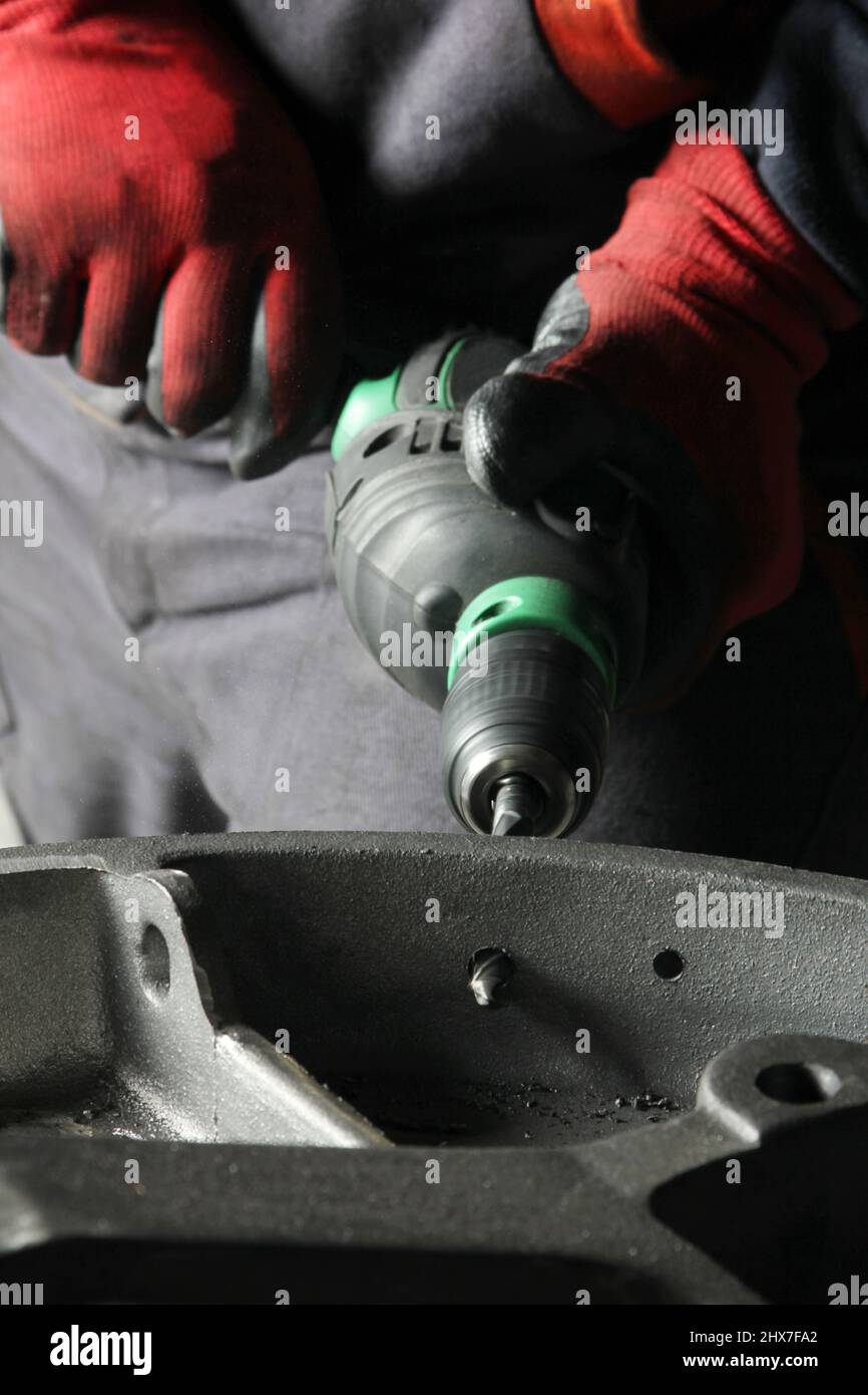 worker with drill in hand in factory Stock Photo - Alamy