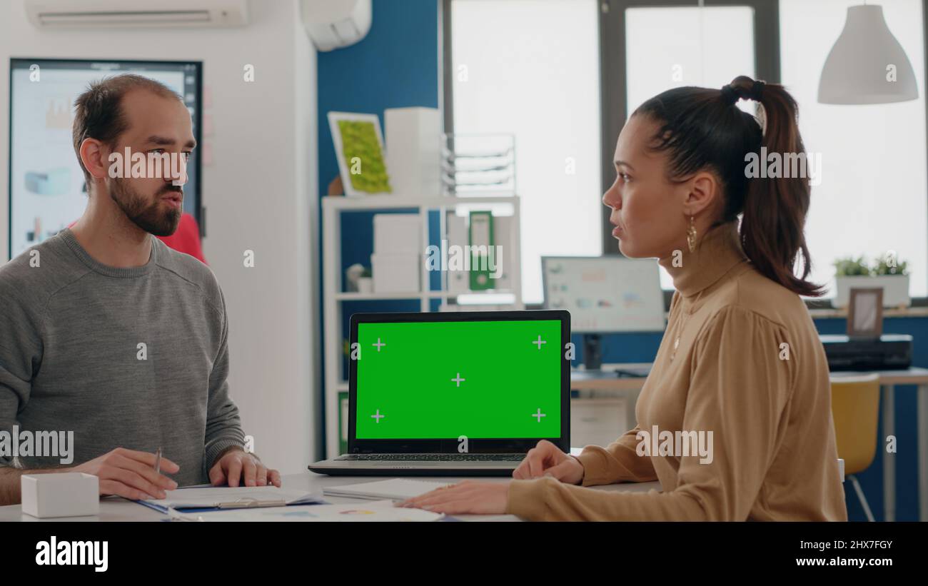 Business people doing teamwork on laptop with green screen at desk ...