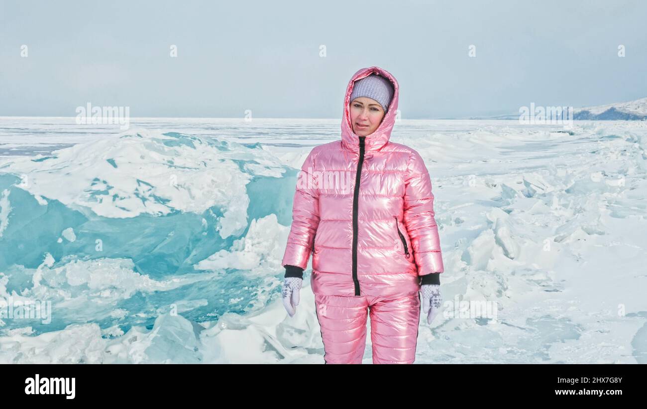 Girl walking on cracked ice of frozen lake Baikal. Woman traveler ...