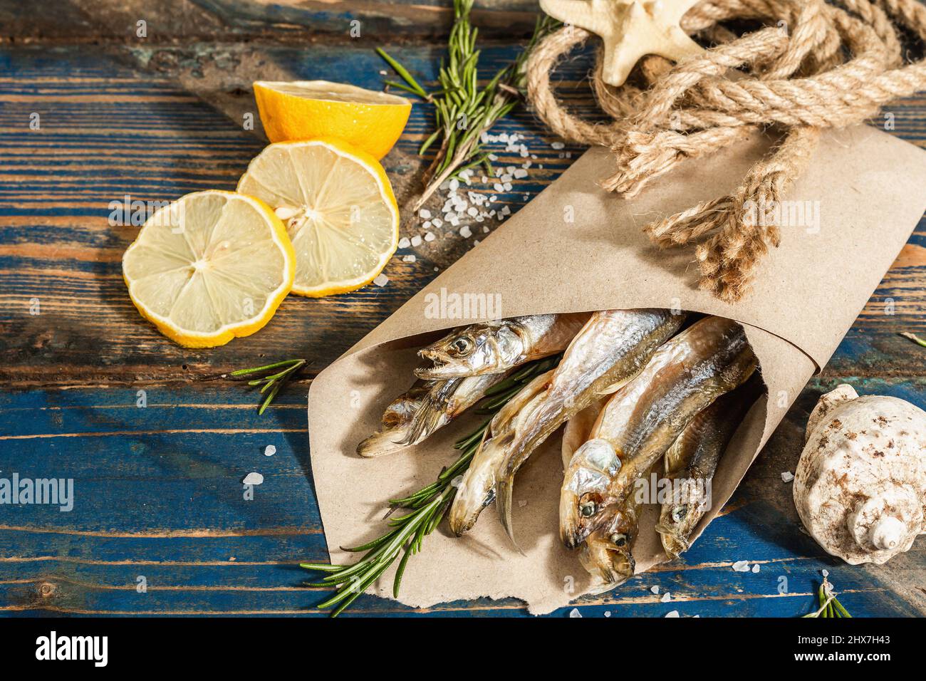 Sun-dried smelt in a paper package. Salted fish with marine decor ...