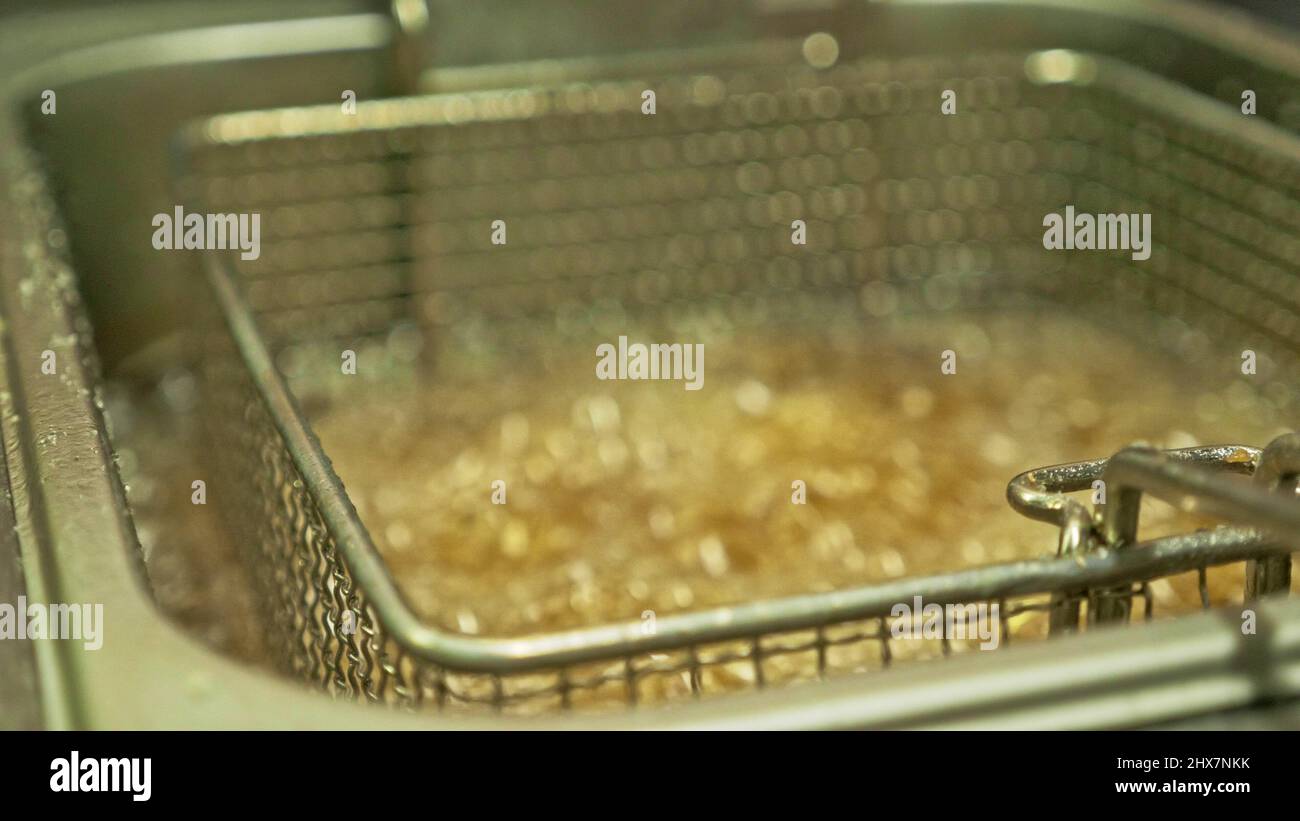 Fast food. Deep fryer with boiling oil and chicken. Large, deeps fryed ...