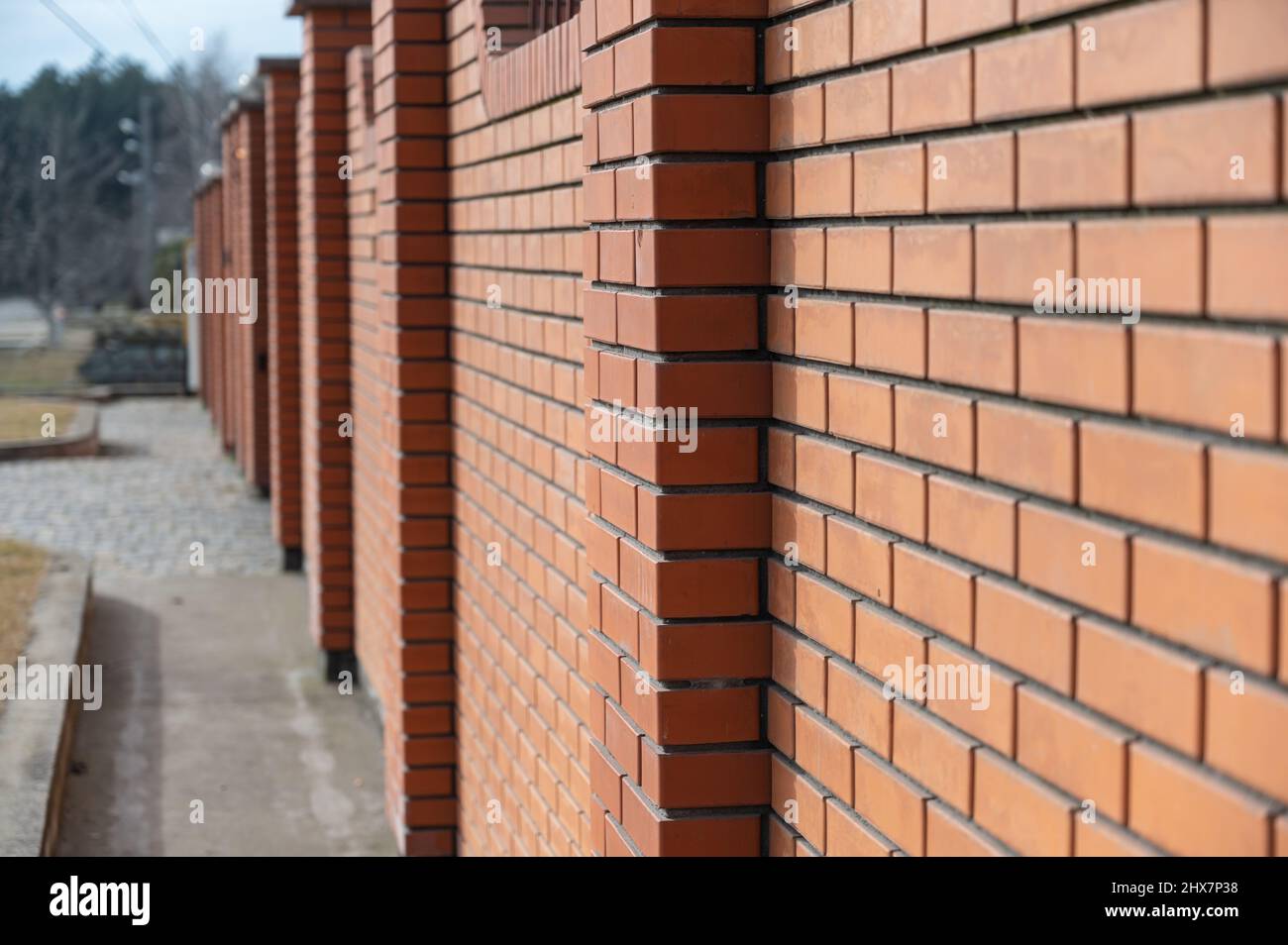 A tall red fence in a receding perspective. An architectural structure ...