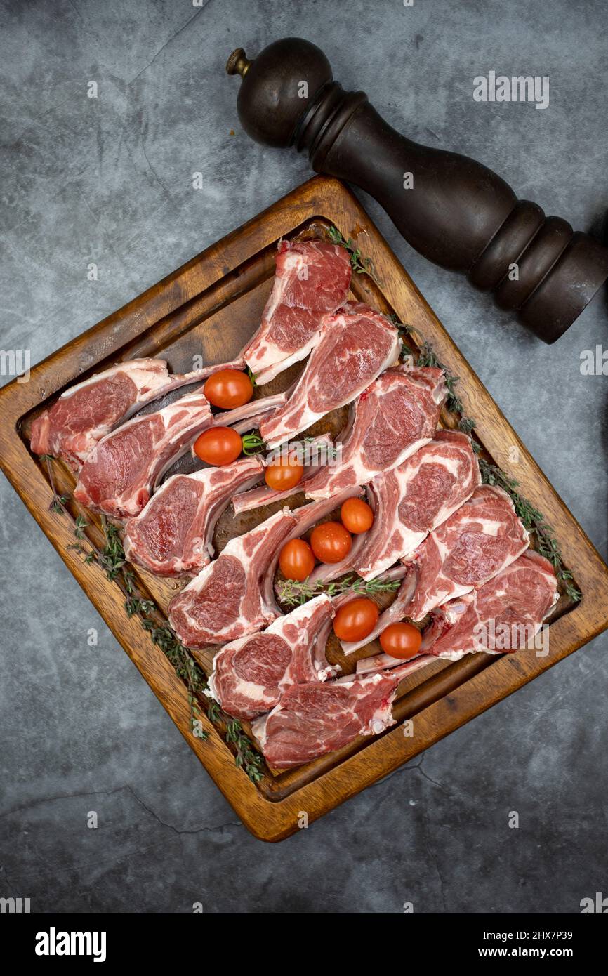 Lamb chops on dark background. Raw lamb chops on wood serving board ...
