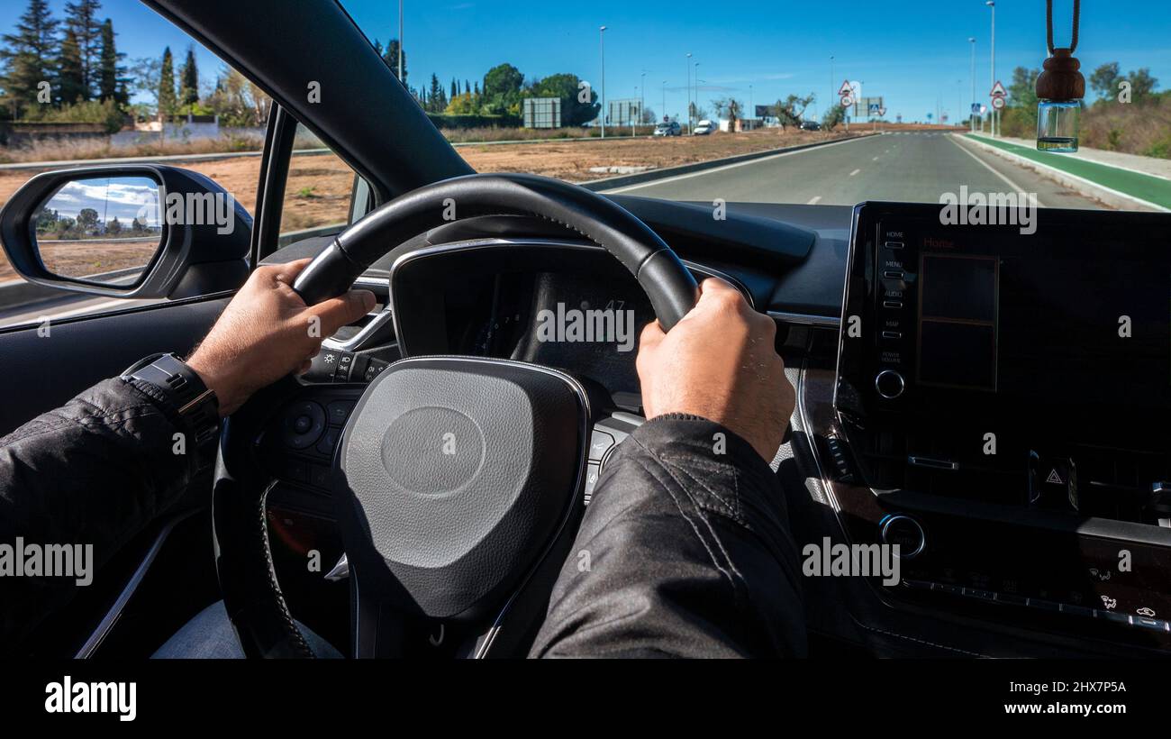 Cropped of man driving car, over shoulder shot. Unrecognizable ...