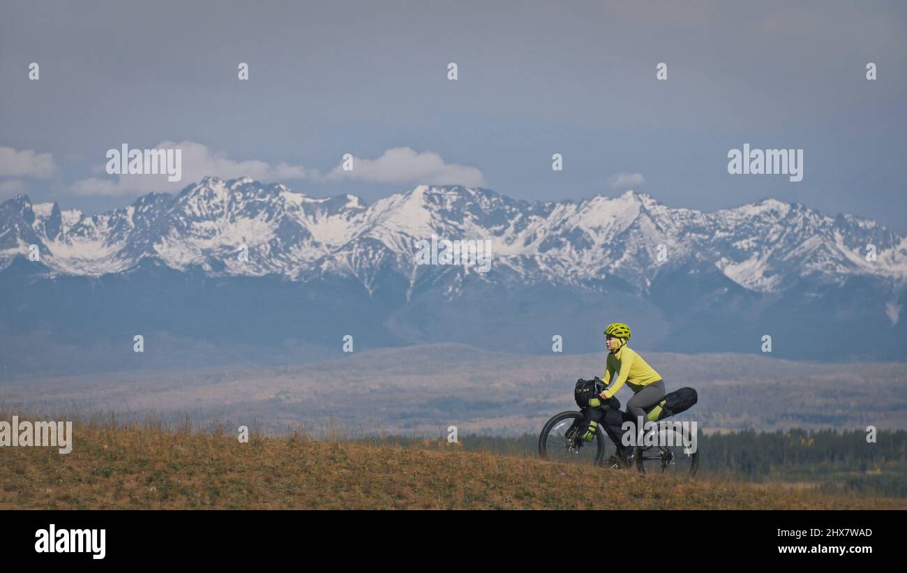 The woman travel on mixed terrain cycle touring with bikepacking. The ...