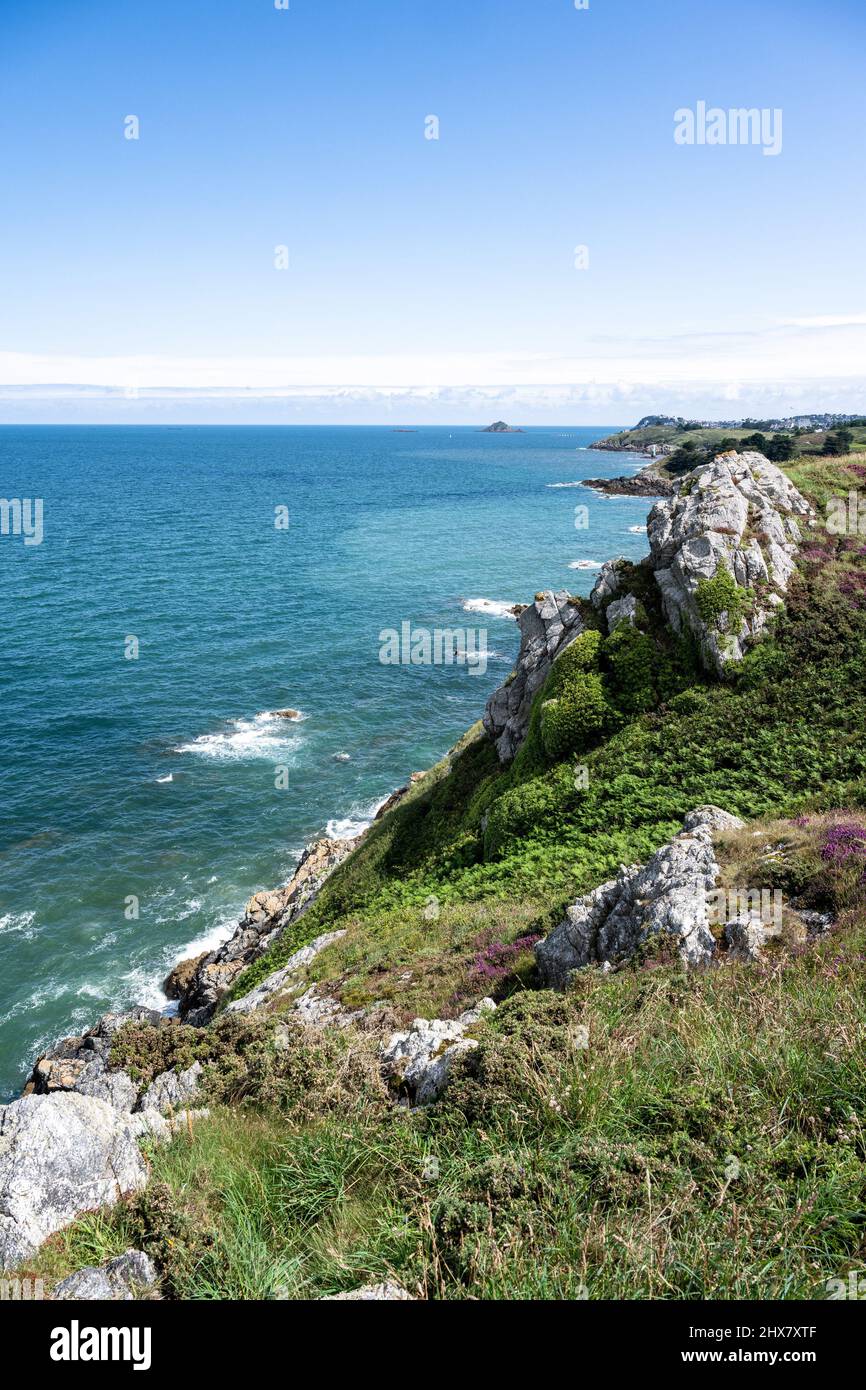 Green-guarded cliffs drop precipitously into the strong blue shining ...