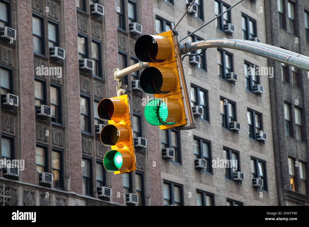 Yellow traffic lights with green light on the background of a high-rise ...