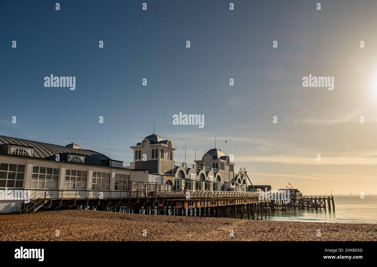 Seaside pier against a shingle beach. Taken on a bright day with strong ...