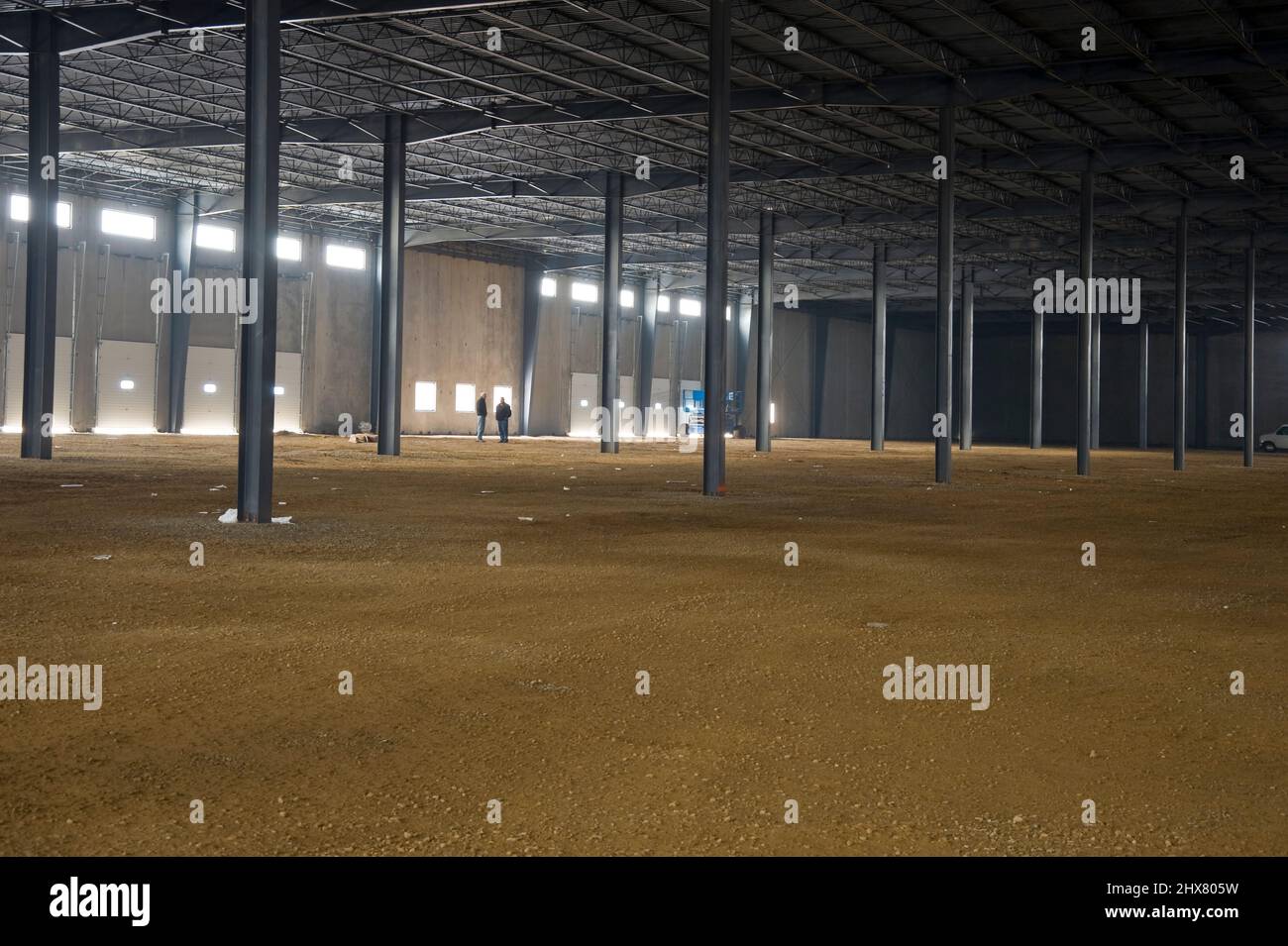 Warehouse under construction with two construction workers in the ...