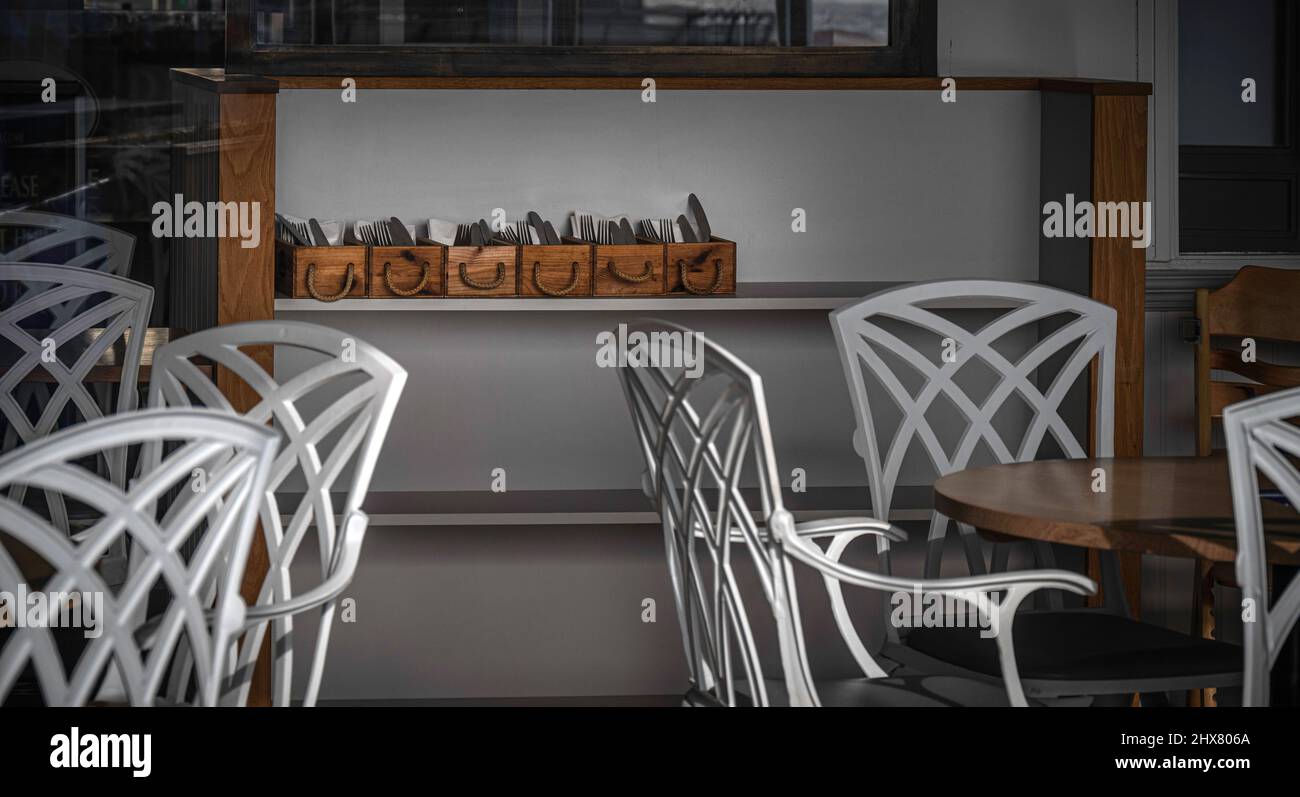 Cafe interior focusing on cutlery containers stacked on a shelf ...