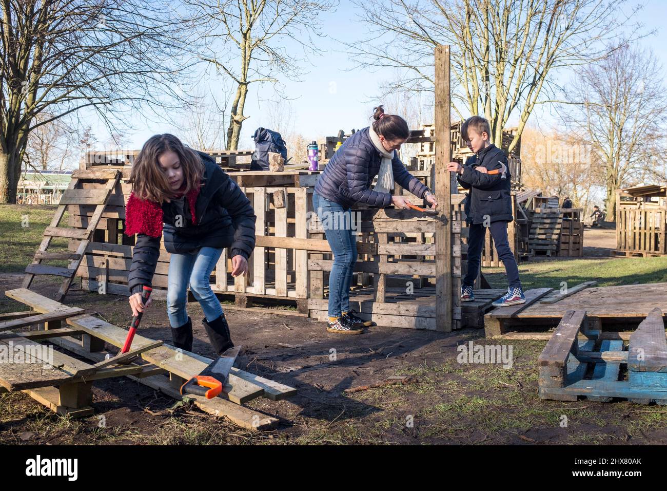 A mother and her young kids build a hut from old pallets at Fort ...