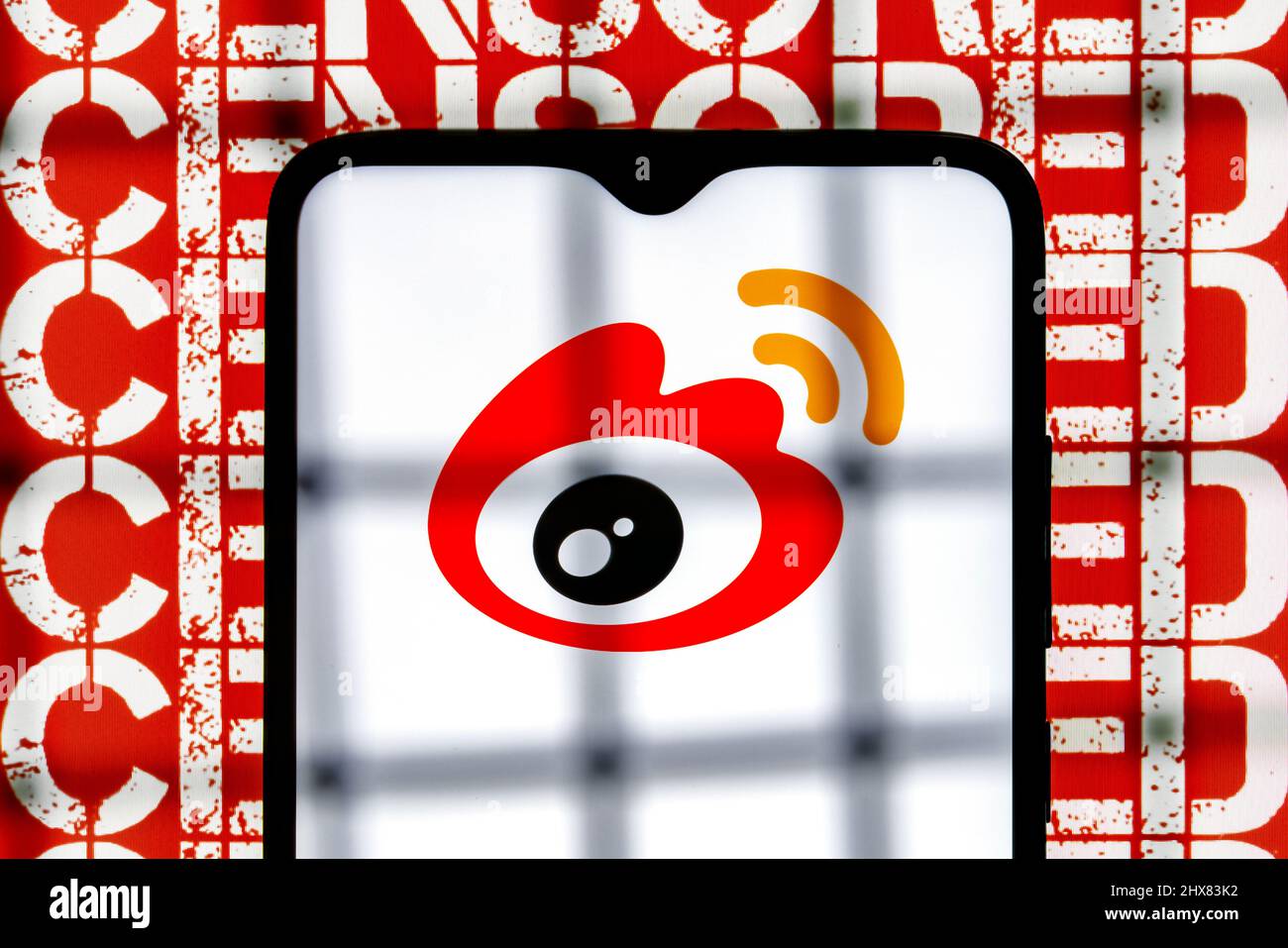 Weibo chinese microblogging service logo on smartphone screen behind ...