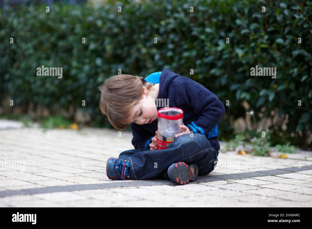Boy looking at toy container Stock Photo - Alamy