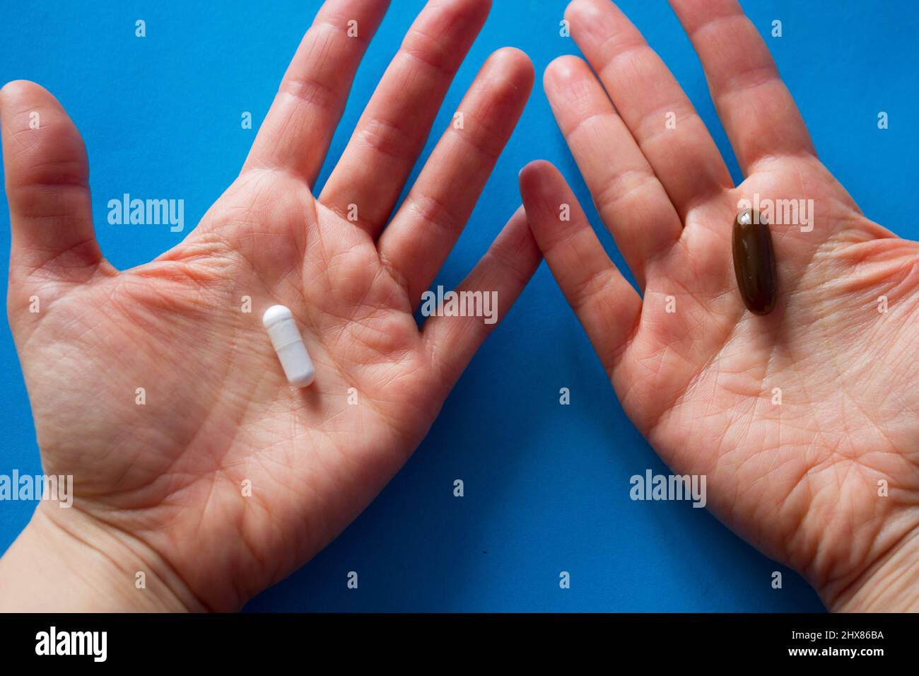 Two pills in hands. A choice concept Stock Photo - Alamy