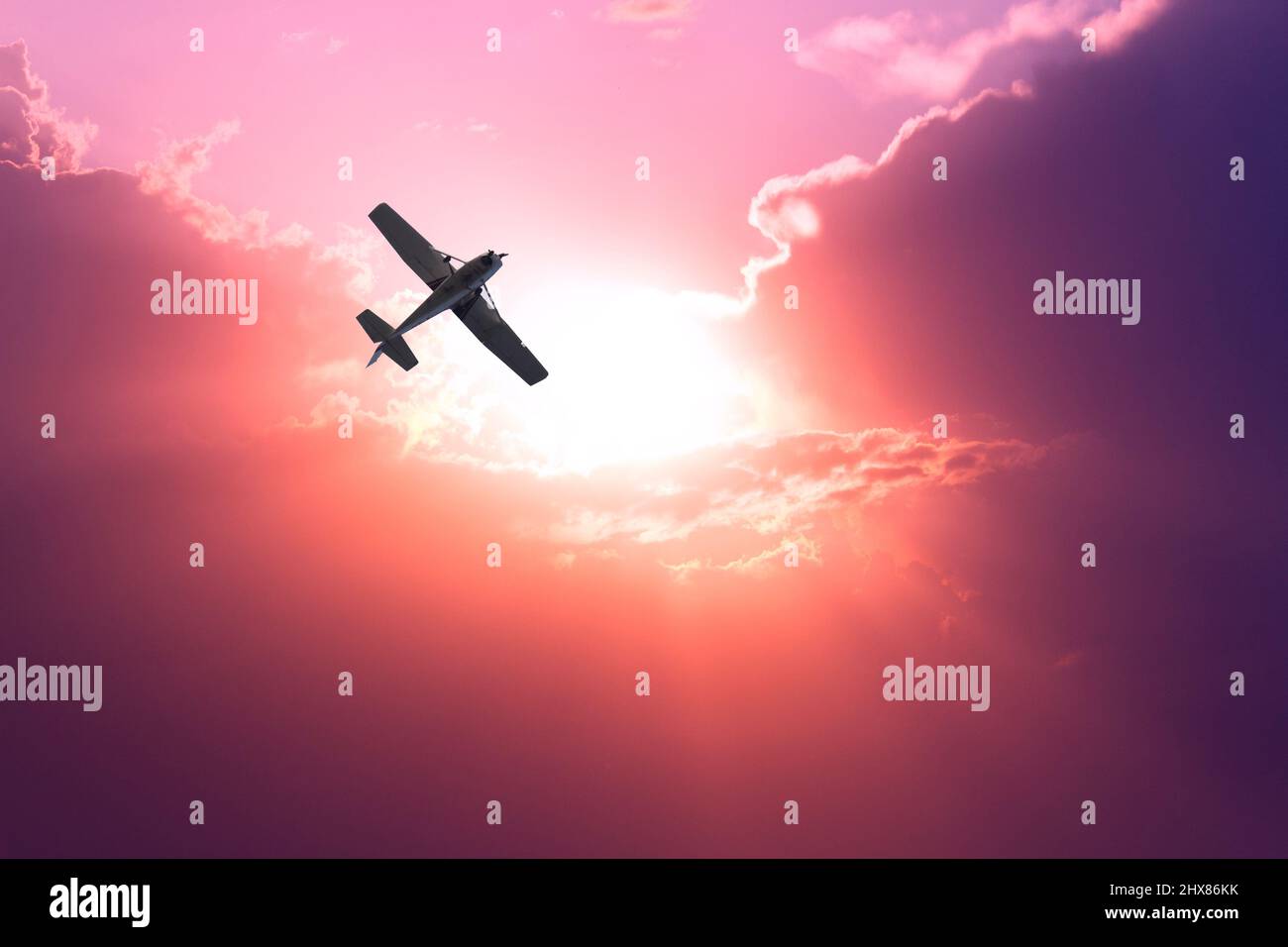 Airplane in the dramatic sunset sky Stock Photo - Alamy