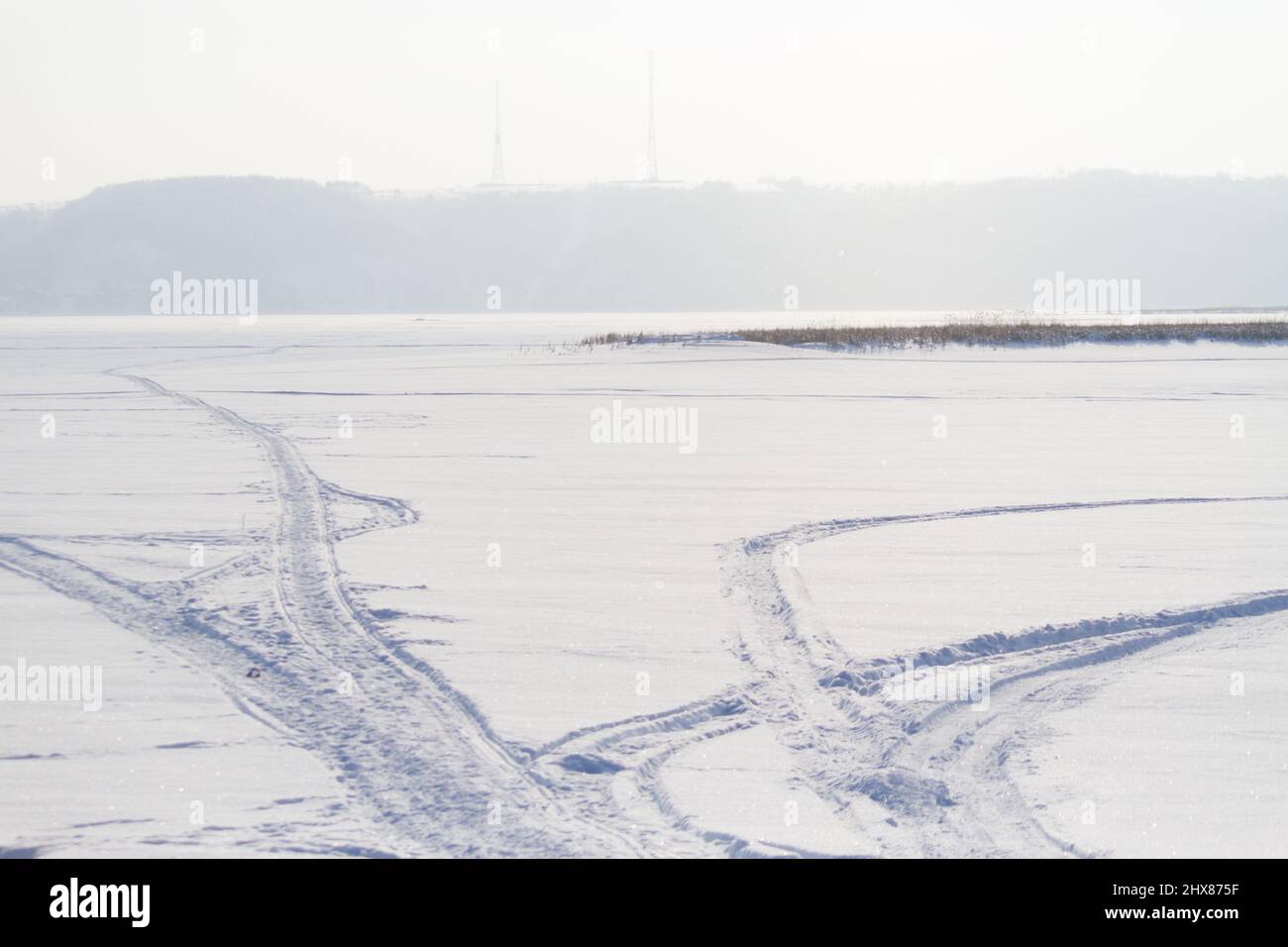 Snowmobile track marks on the snow of frozen river Stock Photo - Alamy
