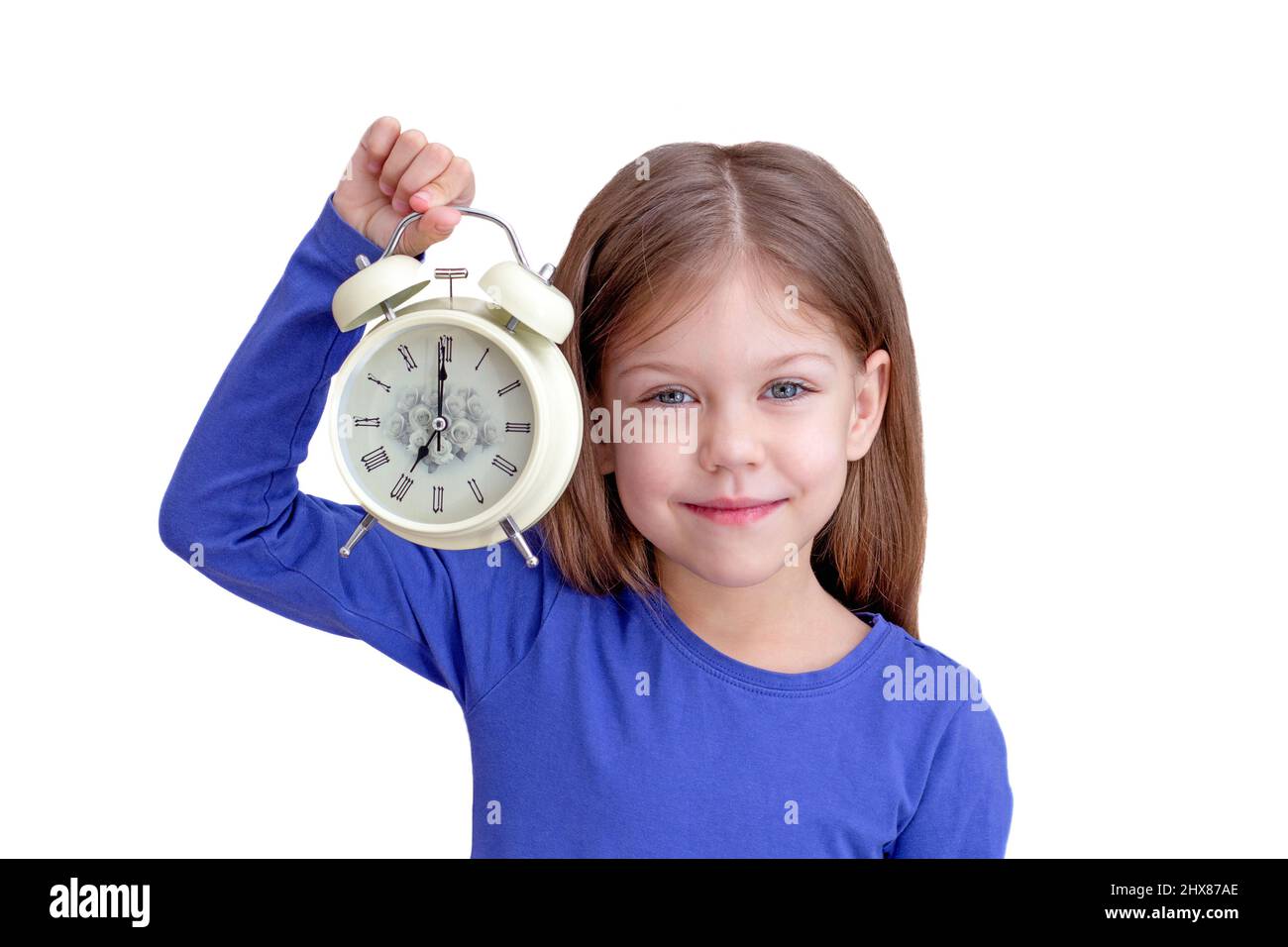 Child holding alarm with 7 o'clock on clock face, isolated on white ...