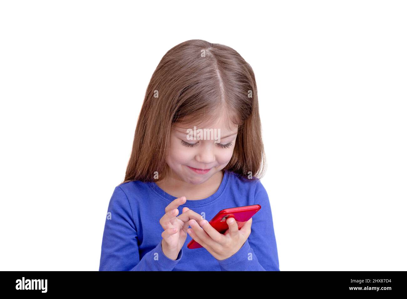 Smiling child looking at mobile phone and touching screen , isolated on ...