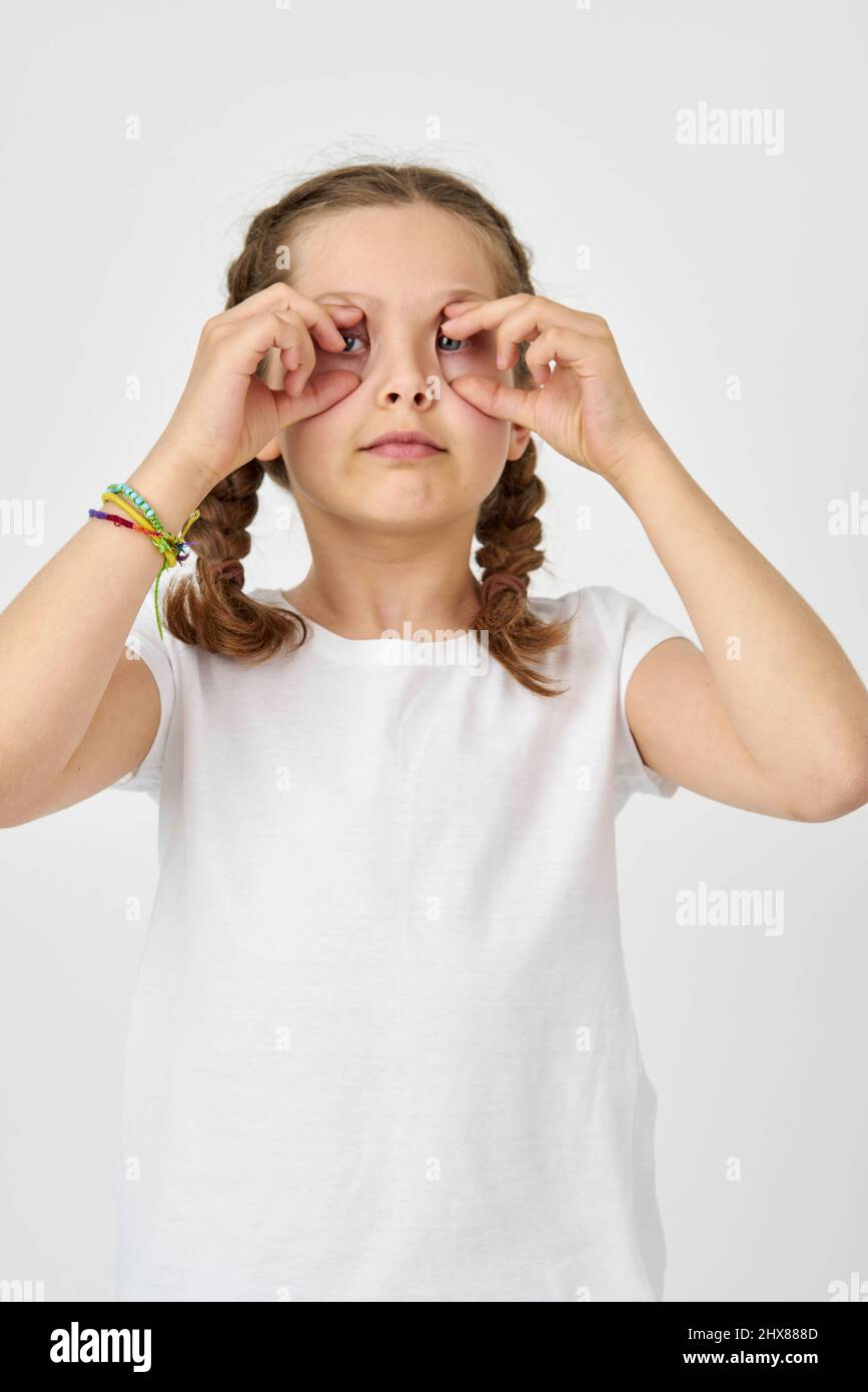 Girl keeping her eyes open with her fingers Stock Photo - Alamy