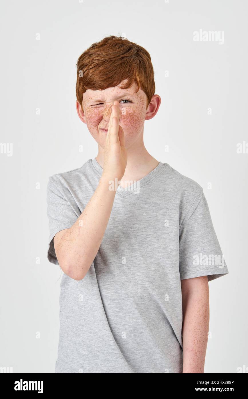 Boy with his right hand held up to his face, with only his right eye ...