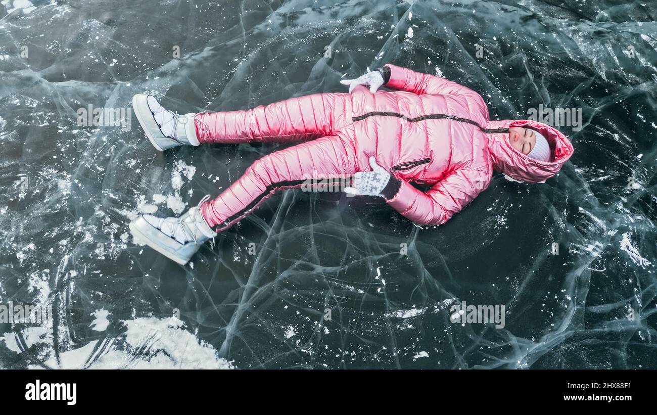 Couple has fun winter walk against background of ice of frozen lake ...