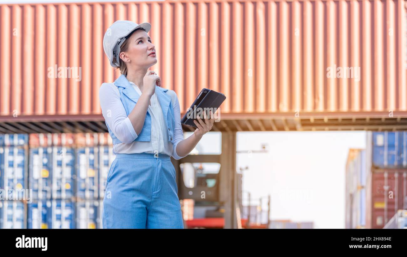 CEO or Manager Woman in white helmet control loading Containers box in ...