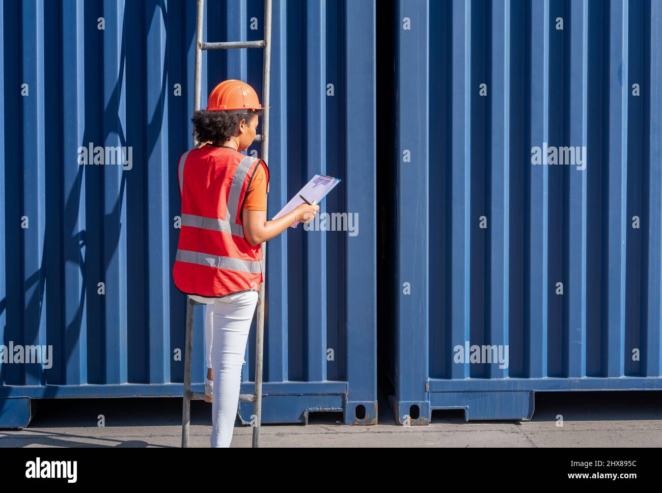 Woman foreman holding file boad for check stock at containers cargo ...