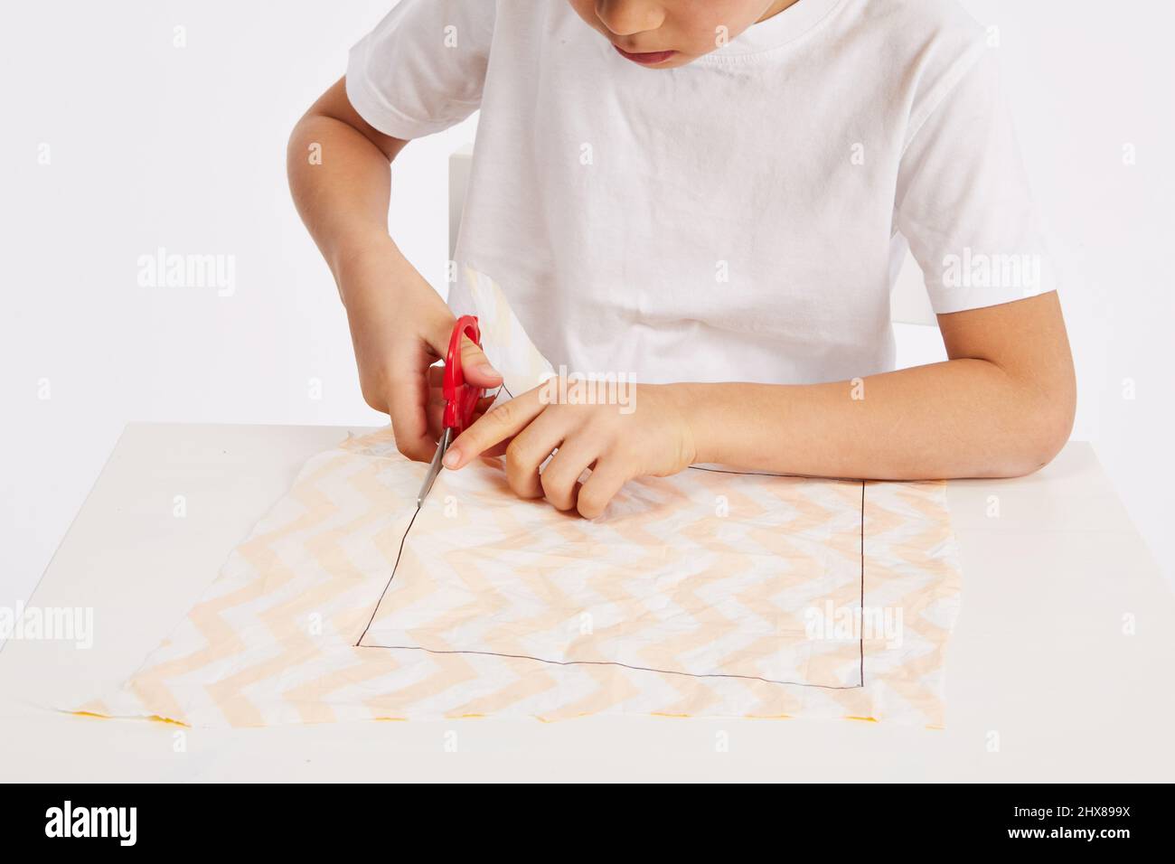 Child cutting out a square of material using scissors Stock Photo - Alamy