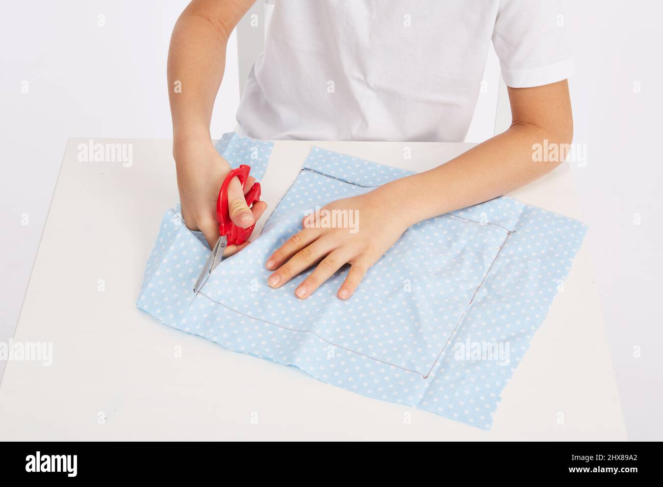 Child cutting out a square of material using scissors Stock Photo - Alamy