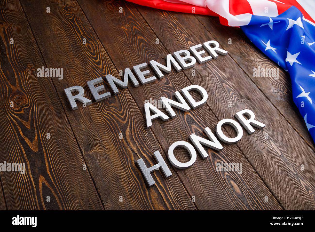 words remember and honor laid with silver metal letters on wooden ...