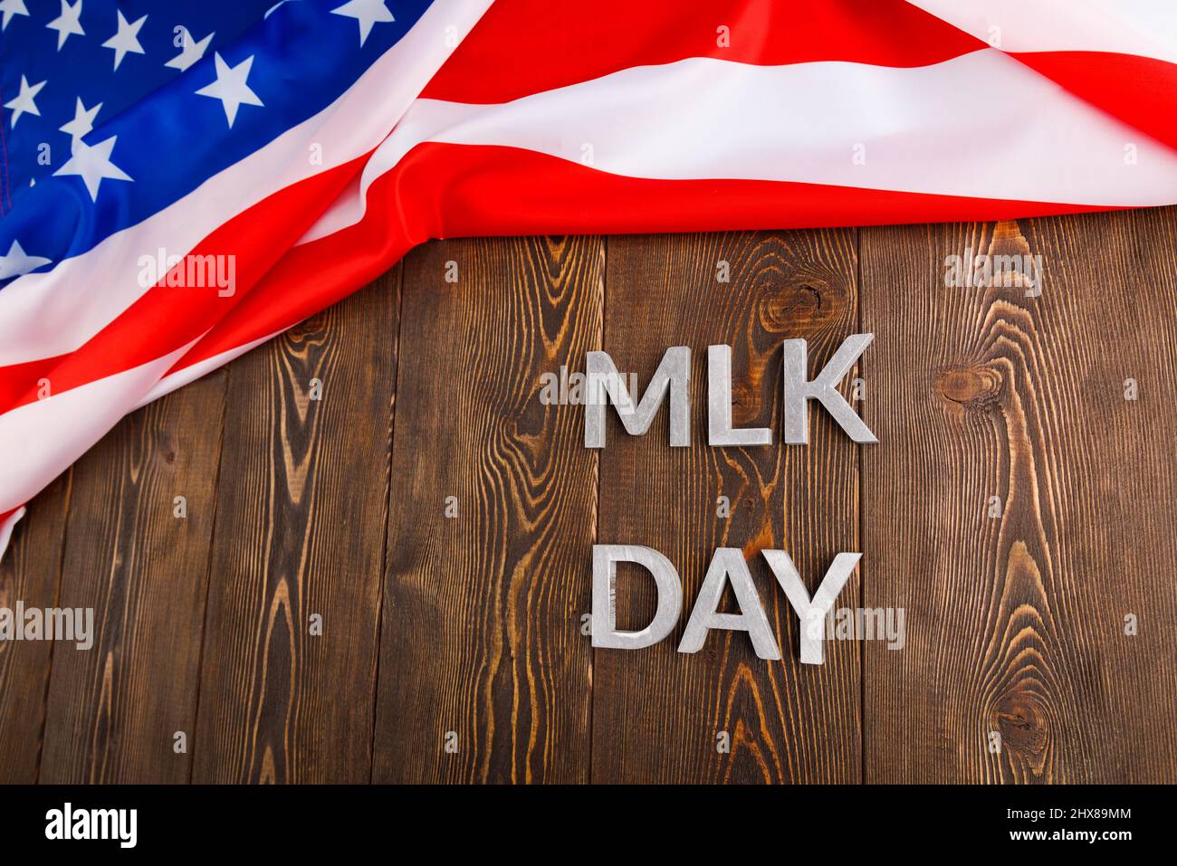 the word MLK day laid with silver metal letters on wooden surface with ...