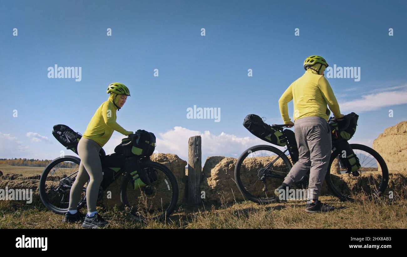 The man and woman travel on mixed terrain cycle touring with ...